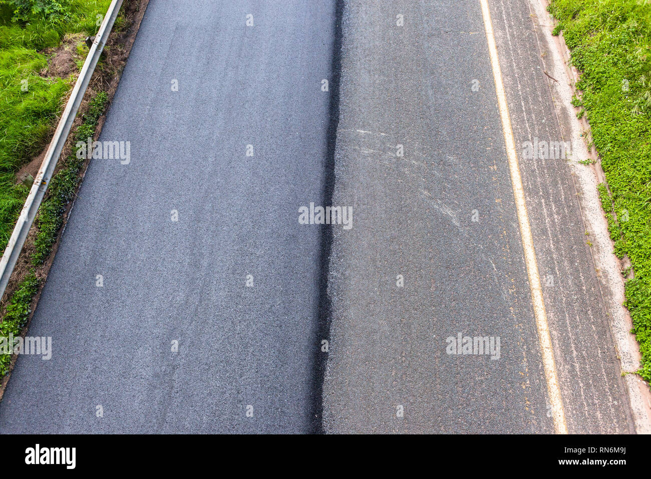 Road highway dual lanes with one lane resurfaced with new asphalt tar ...