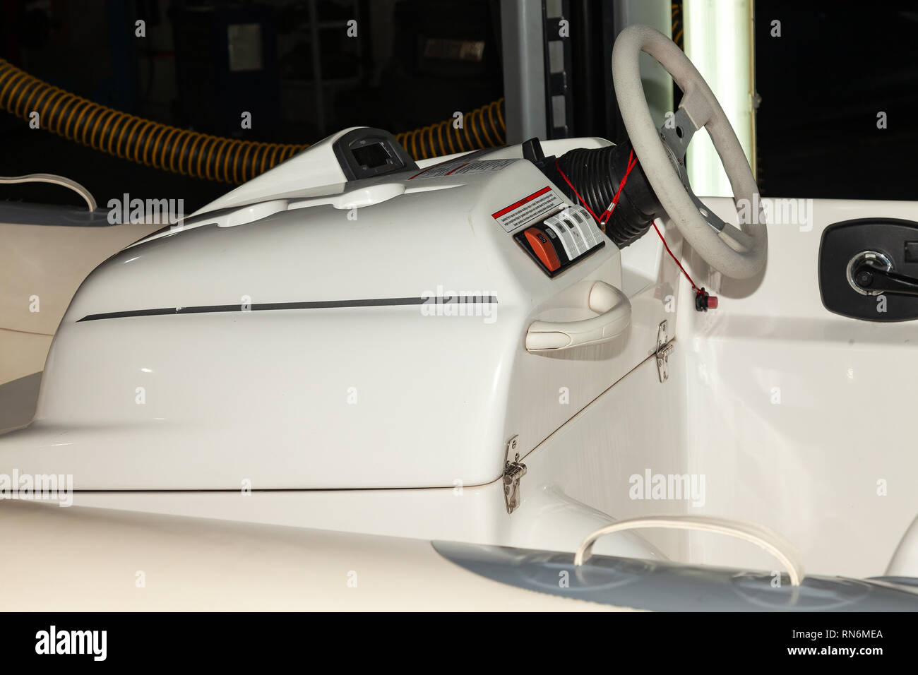 A close-up view of the steering wheel of a small white rubber motorboat ...