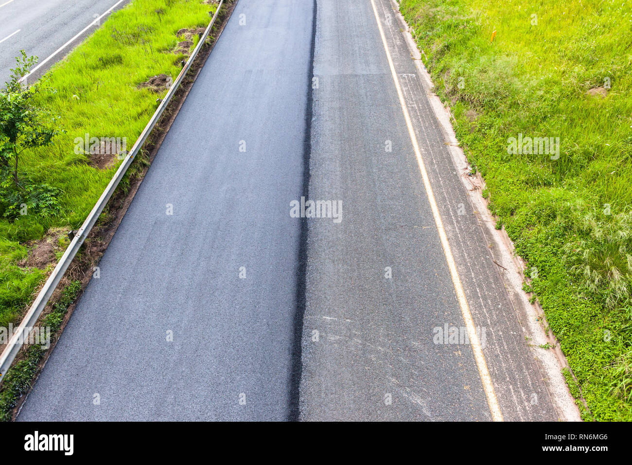 Road highway dual lanes with one lane resurfaced with new asphalt tar ...
