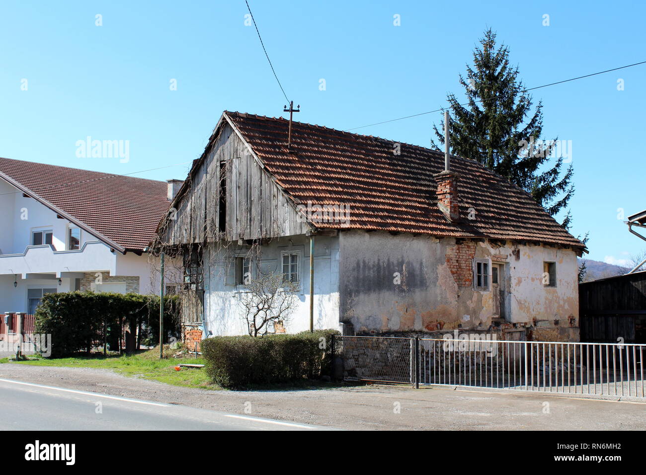 Small dilapidated family house made of wood and concrete abandoned by owners with cracked facade ...
