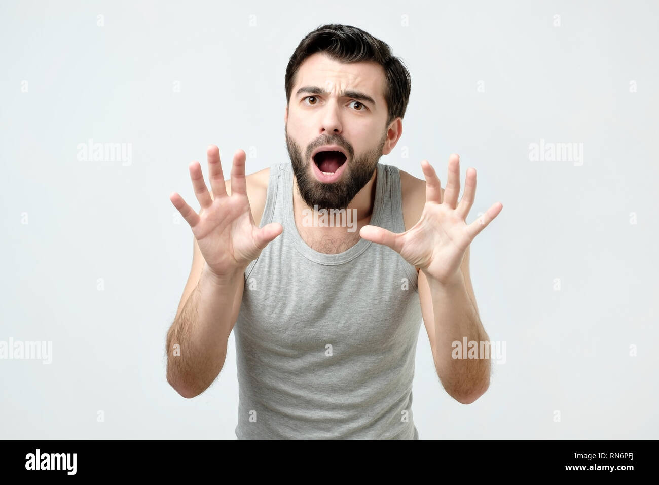 Young man is afraid and terrified with fear expression stop gesture ...