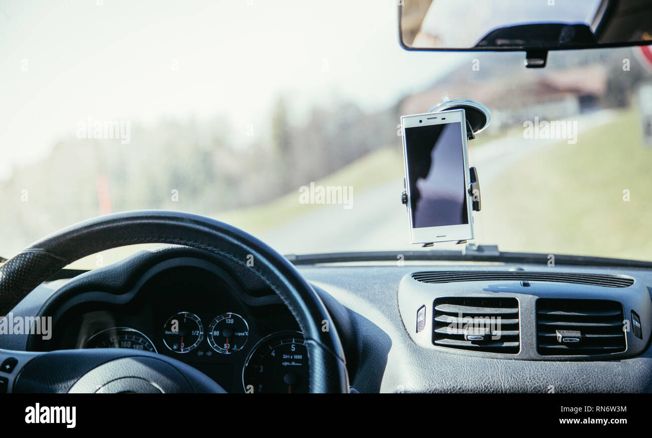 Interior of a modern car on a sunny day. Smartphone on mobile mount ...