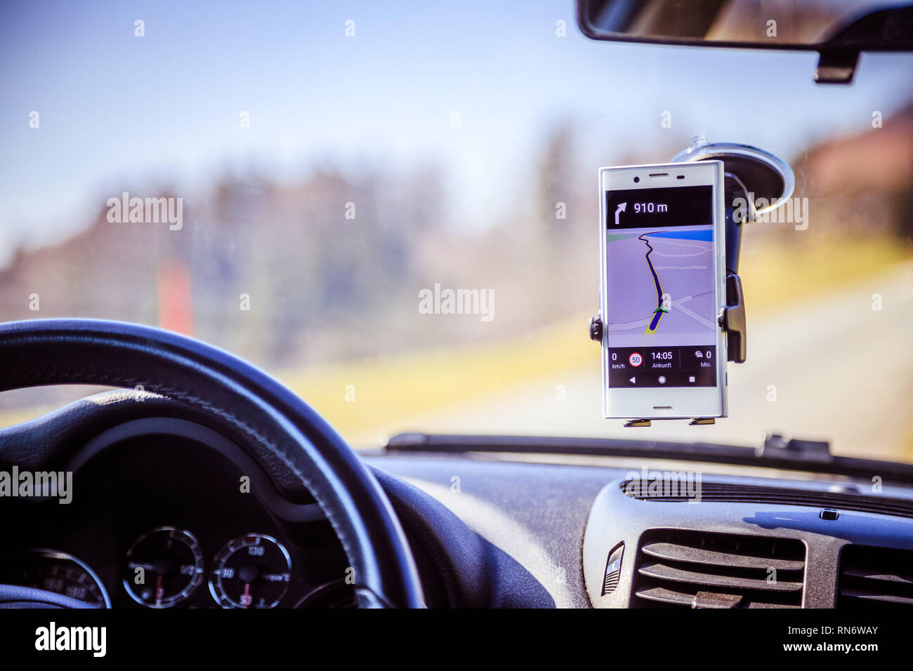 Interior of a modern car on a sunny day. Smartphone on mobile mount ...