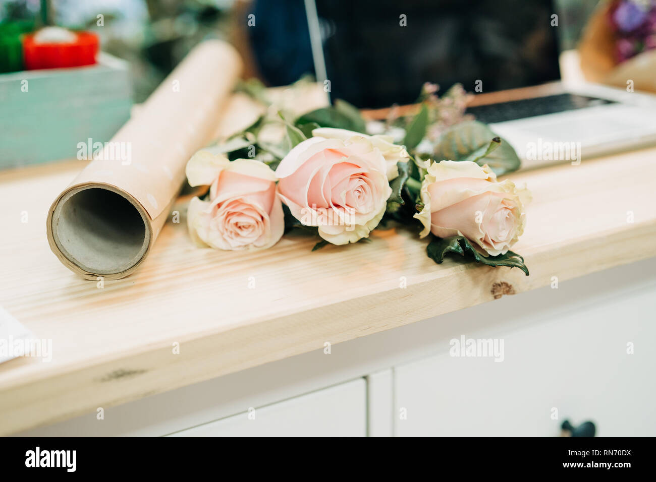 Florist's Desk. On the table laptop, roses, eucalyptus, paper, flowers ...