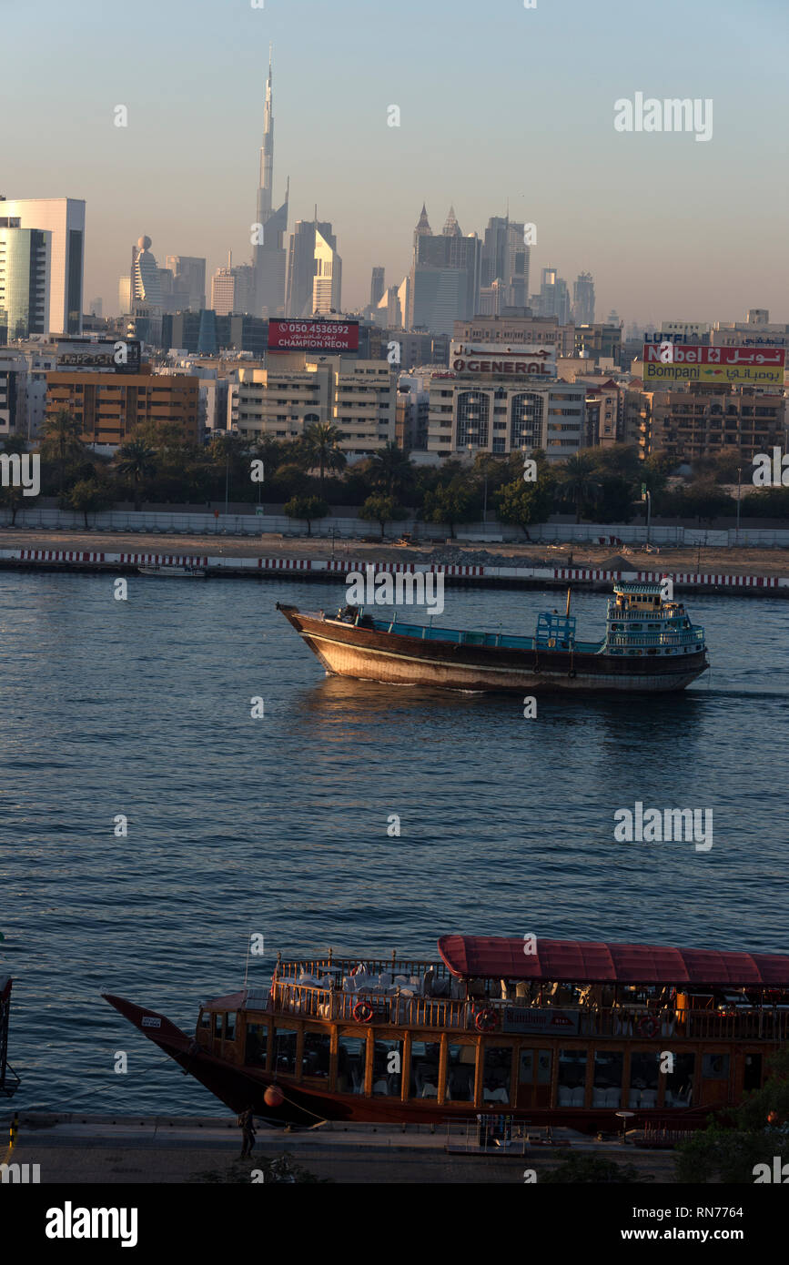 Early morning as a Dhow (Arab boat) cruises on the Dubai Creek in Dubai ...
