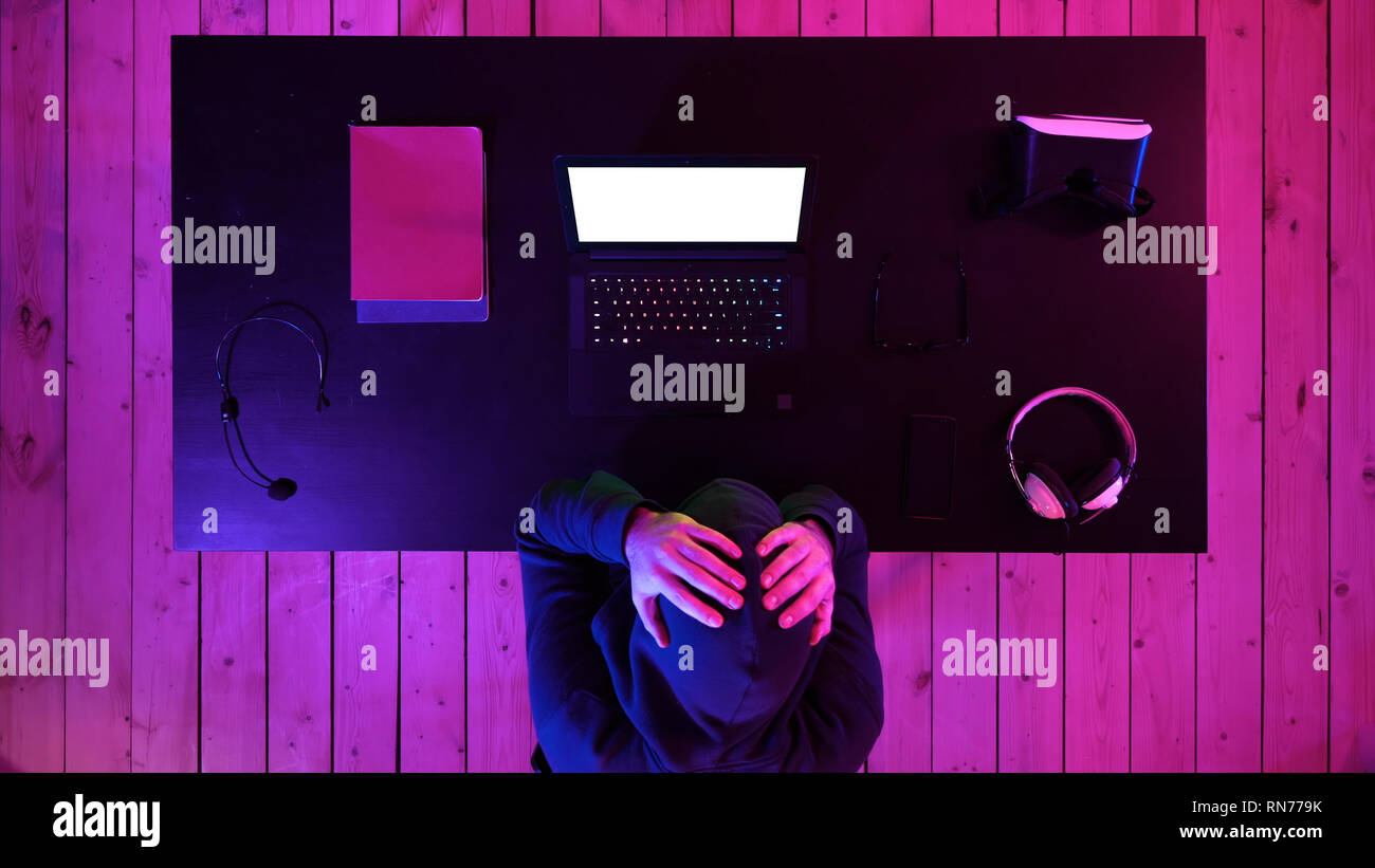 Sad gamer sits at home behind the computer and cries of defeat in the ...
