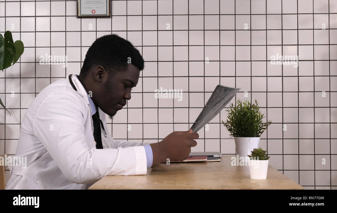 Brain structure. Afro american male doctor looking at x-ray of a brain ...