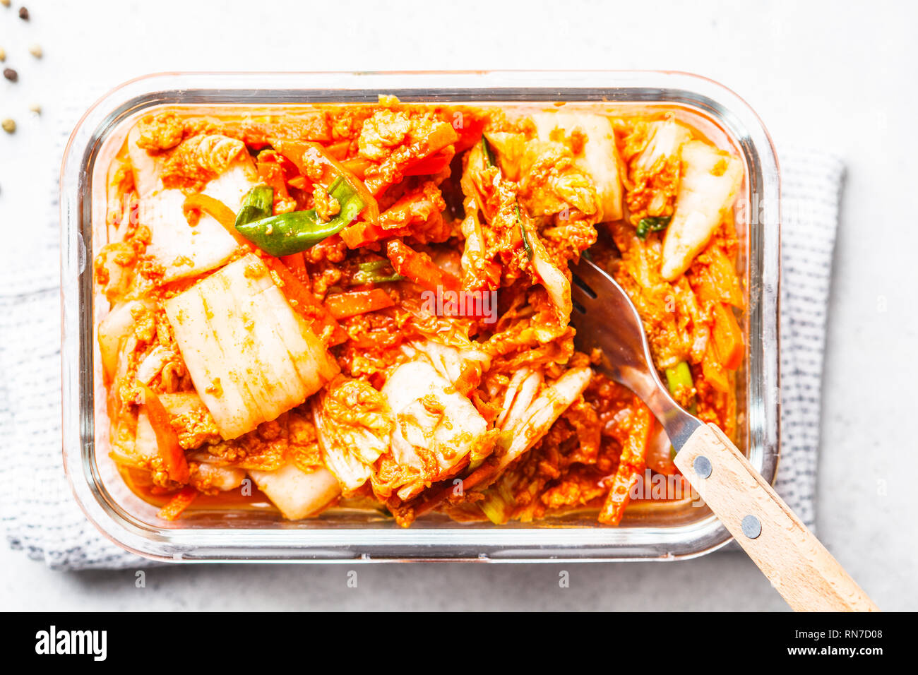 Kimchi cabbage in a glass container, white background, top view. Korean ...