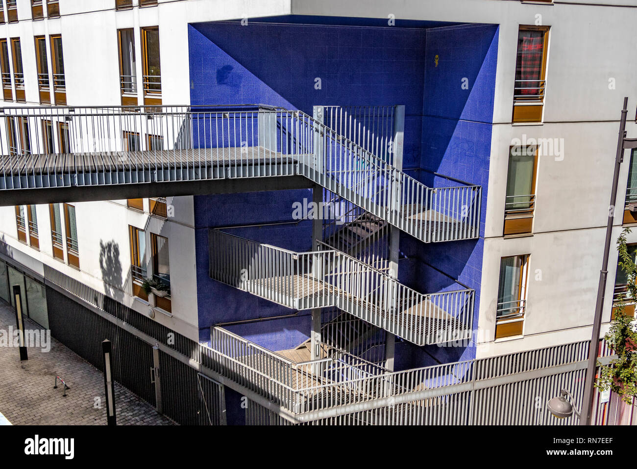 Metal railings and stairs contrast with a blue mosaic tiled inlay on ...