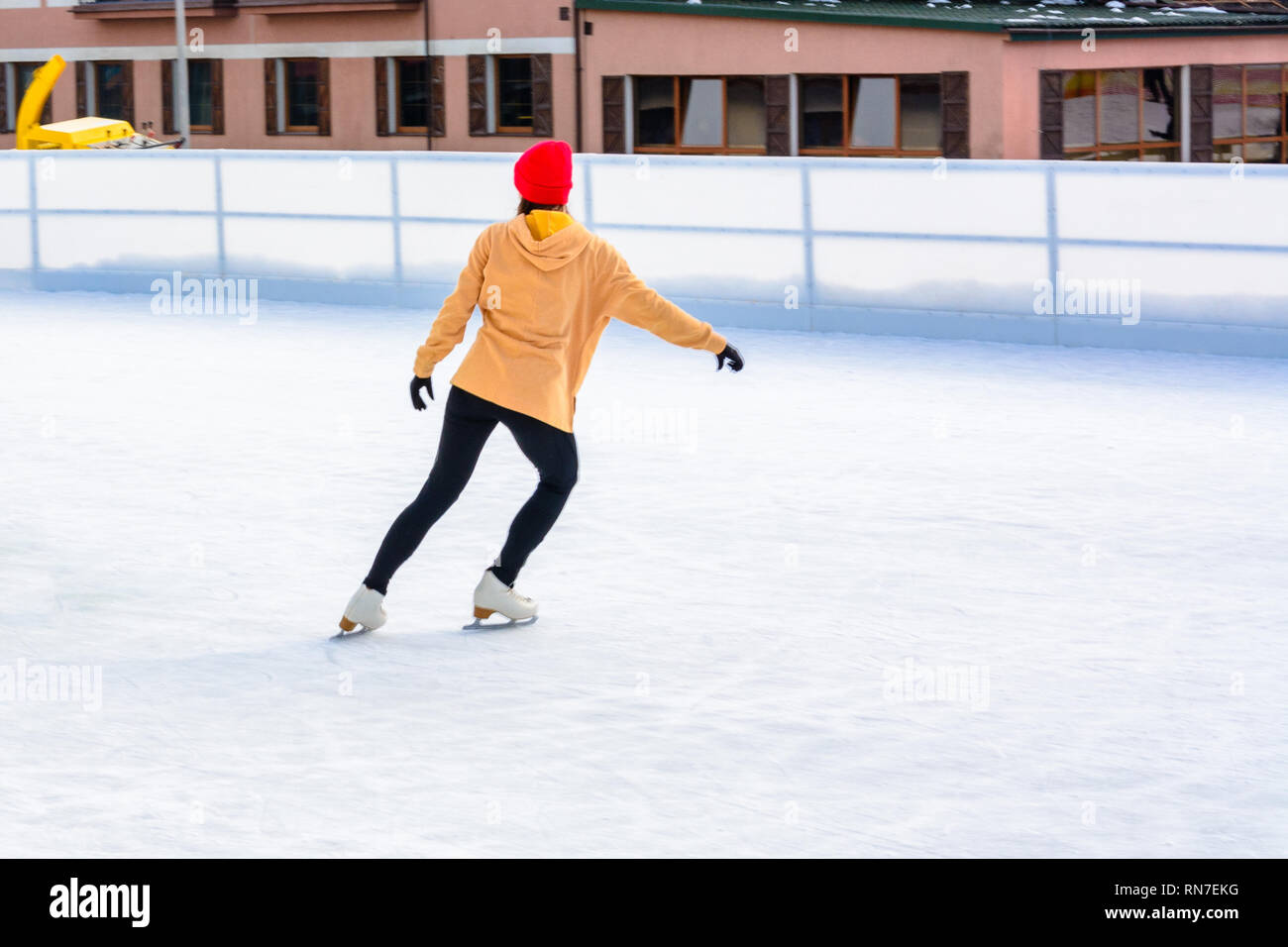 A young, slim girl in outdoor figure skating on a roller skating rink ...