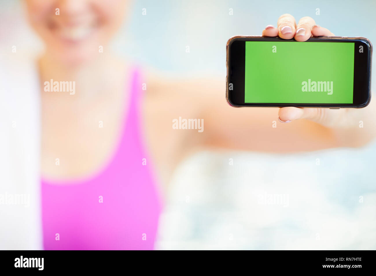 Woman Presenting Smartphone in Pool Stock Photo - Alamy