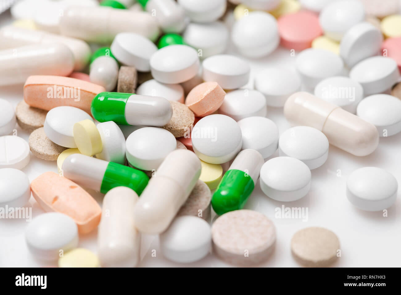 Colorful medication and pills. Close-up of pile of yellow, green, pink ...