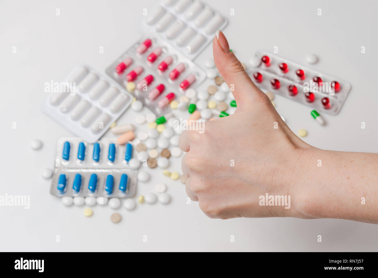 Female showing thumb up for medicine pills and tablets. Woman approve ...