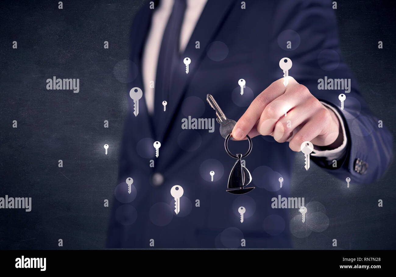 Businessman in suit holding keys with keys graphics around and dark ...