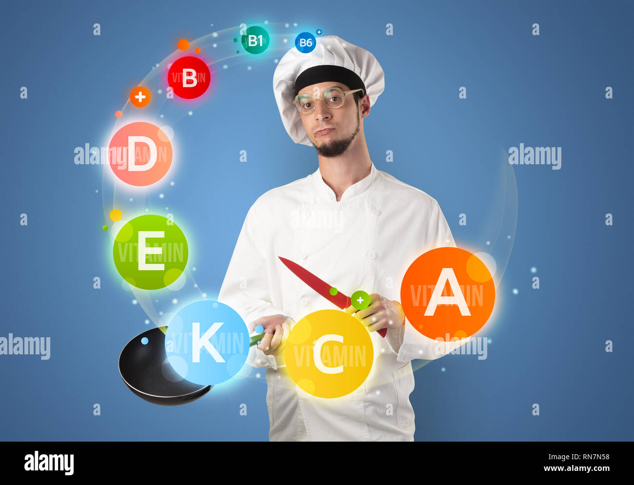 Handsome cook with kitchen instruments and vitamin concept Stock Photo ...