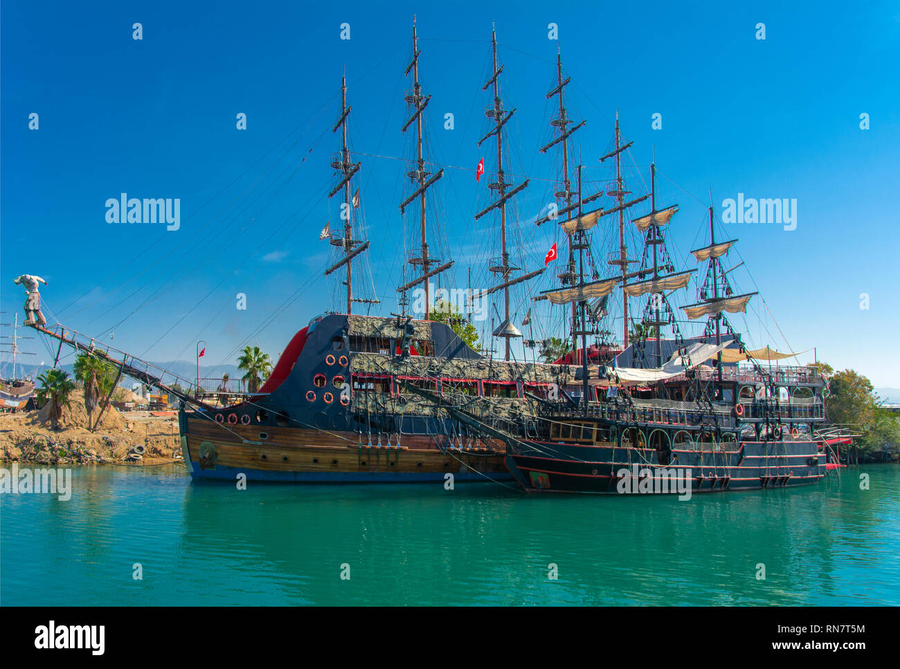 A small sailing ship with tourists passes along the coast against the ...