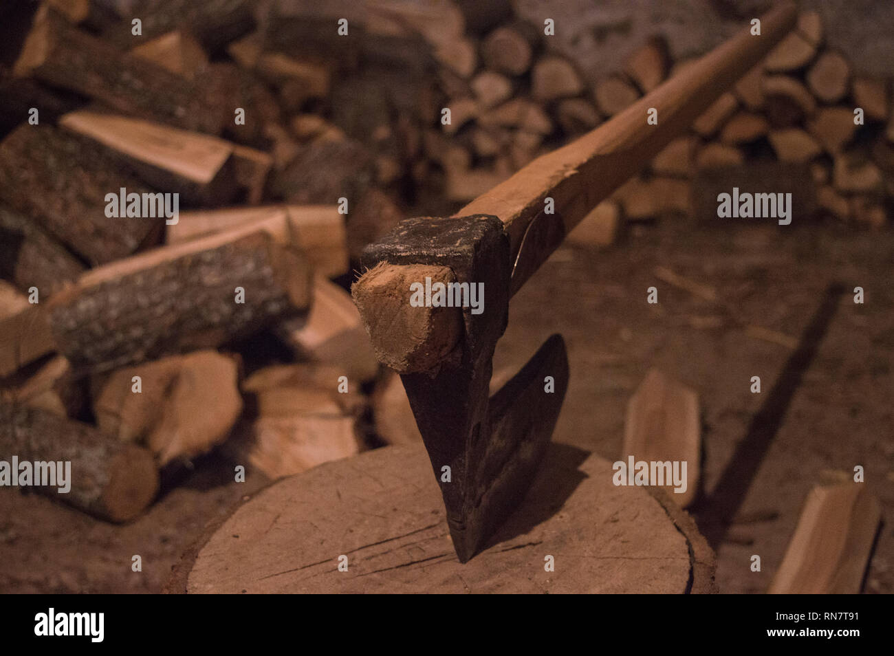 Axe and fire wood in basement Stock Photo - Alamy
