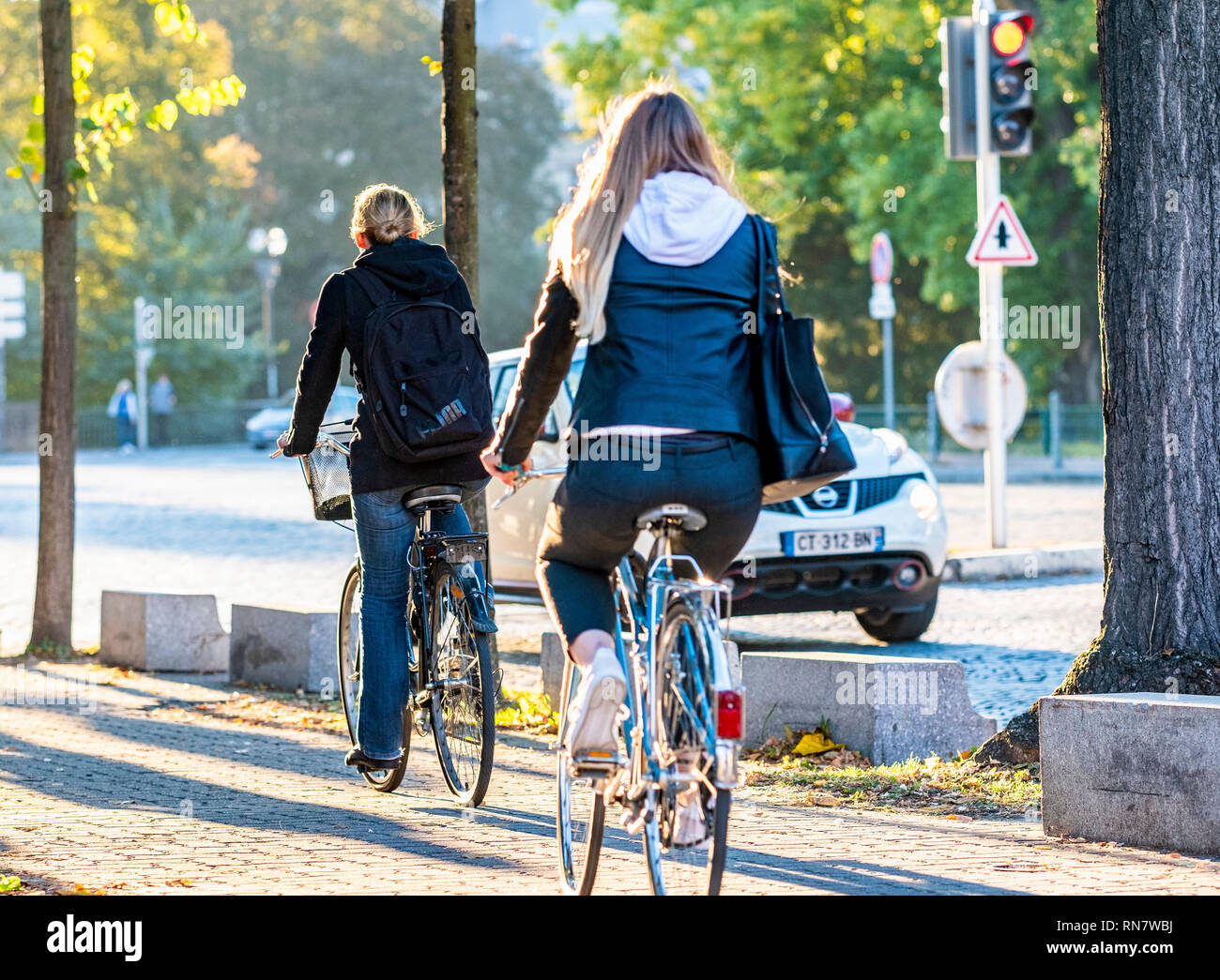 Rear view of 2 women biking on pavement hi-res stock photography and ...