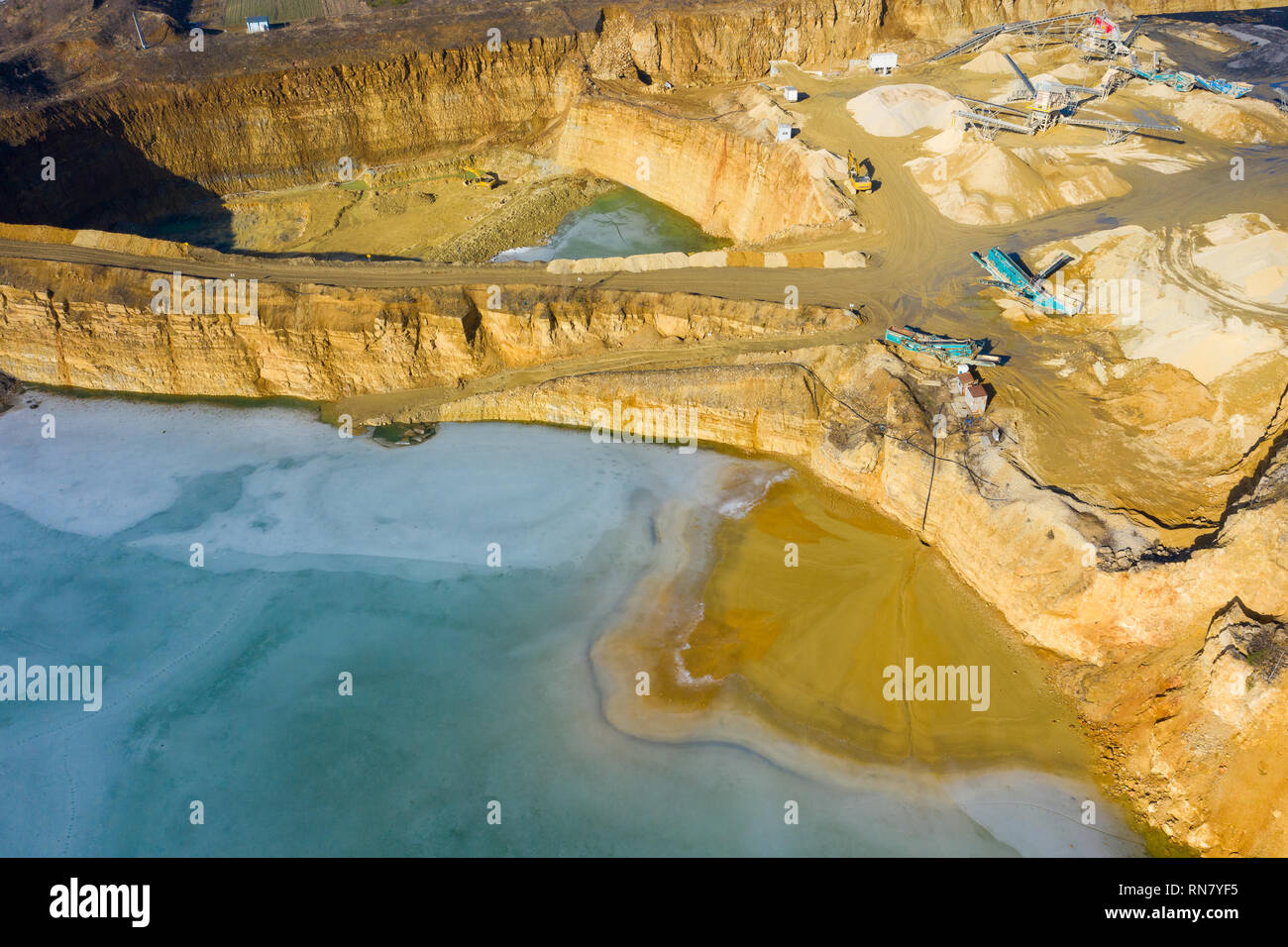 Aerial view of opencast mining quarry with lots of machinery ...