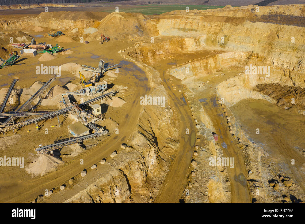 Aerial view of opencast mining quarry with lots of machinery ...