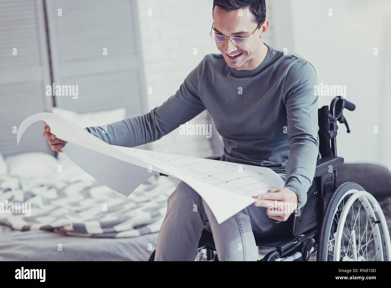 Professional scheme. Smart handicapped man studying the drawing while ...