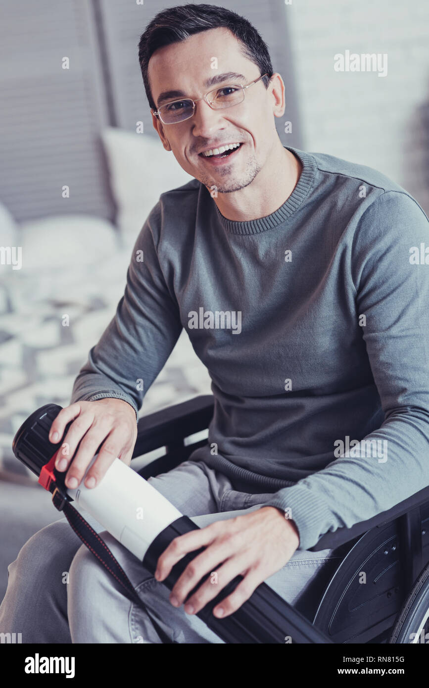 My project. Cheerful disabled engineer holding his blueprint while ...