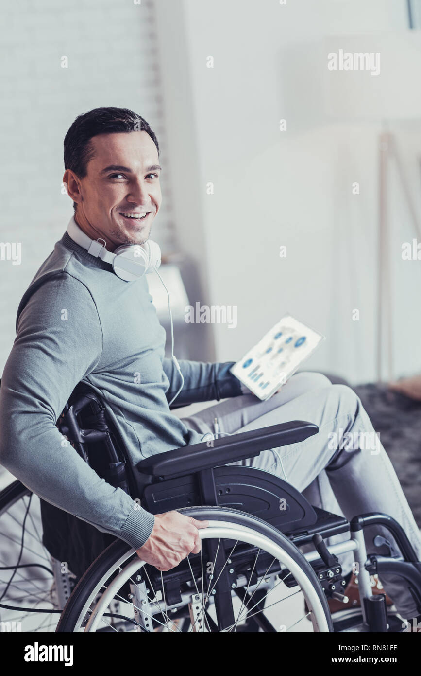 Physically disabled. Delighted handsome man sitting in the wheelchair ...
