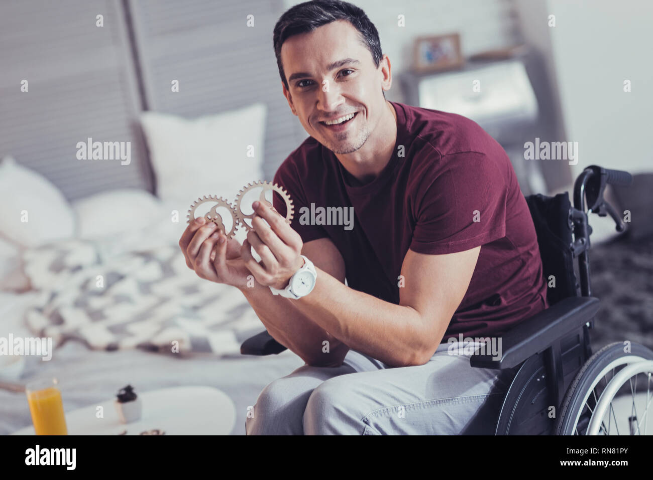Car model details. Happy nice man smiling while holding wooden wheels ...