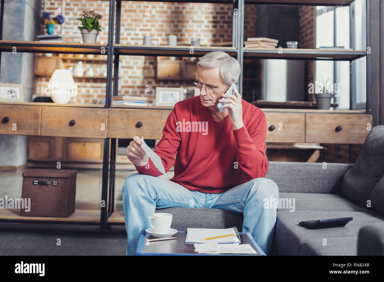 Phone talk. Calm clever aged man looking serious while having an ...