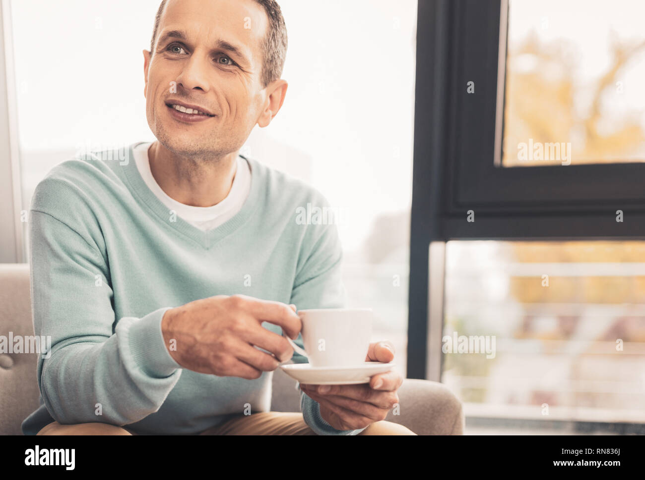 Family time. Smiling father feeling extremely happy while having ...