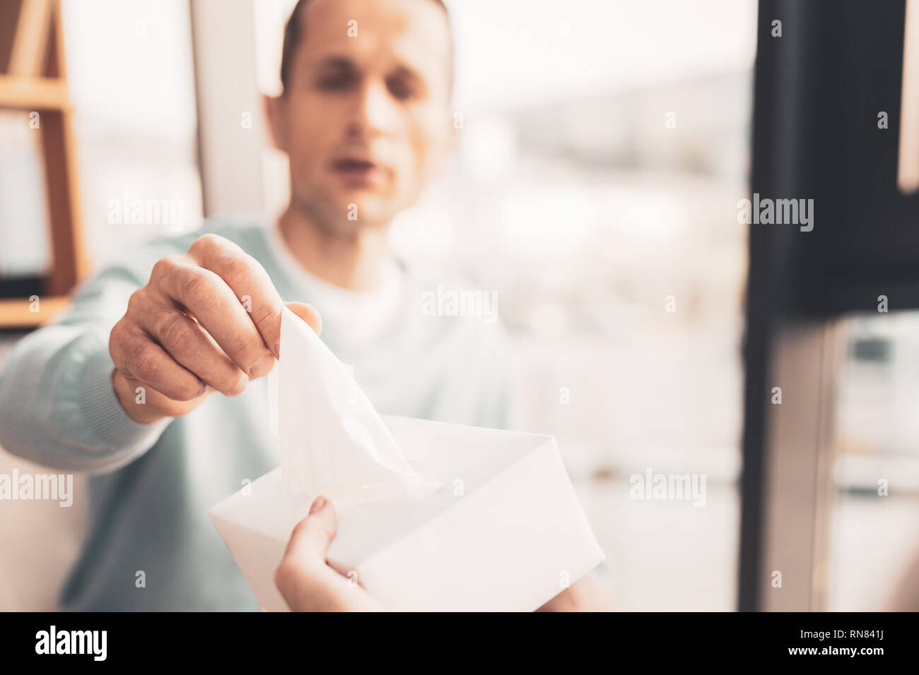 Summer allergy. Sick troubled man taking napkin feeling concerned while ...