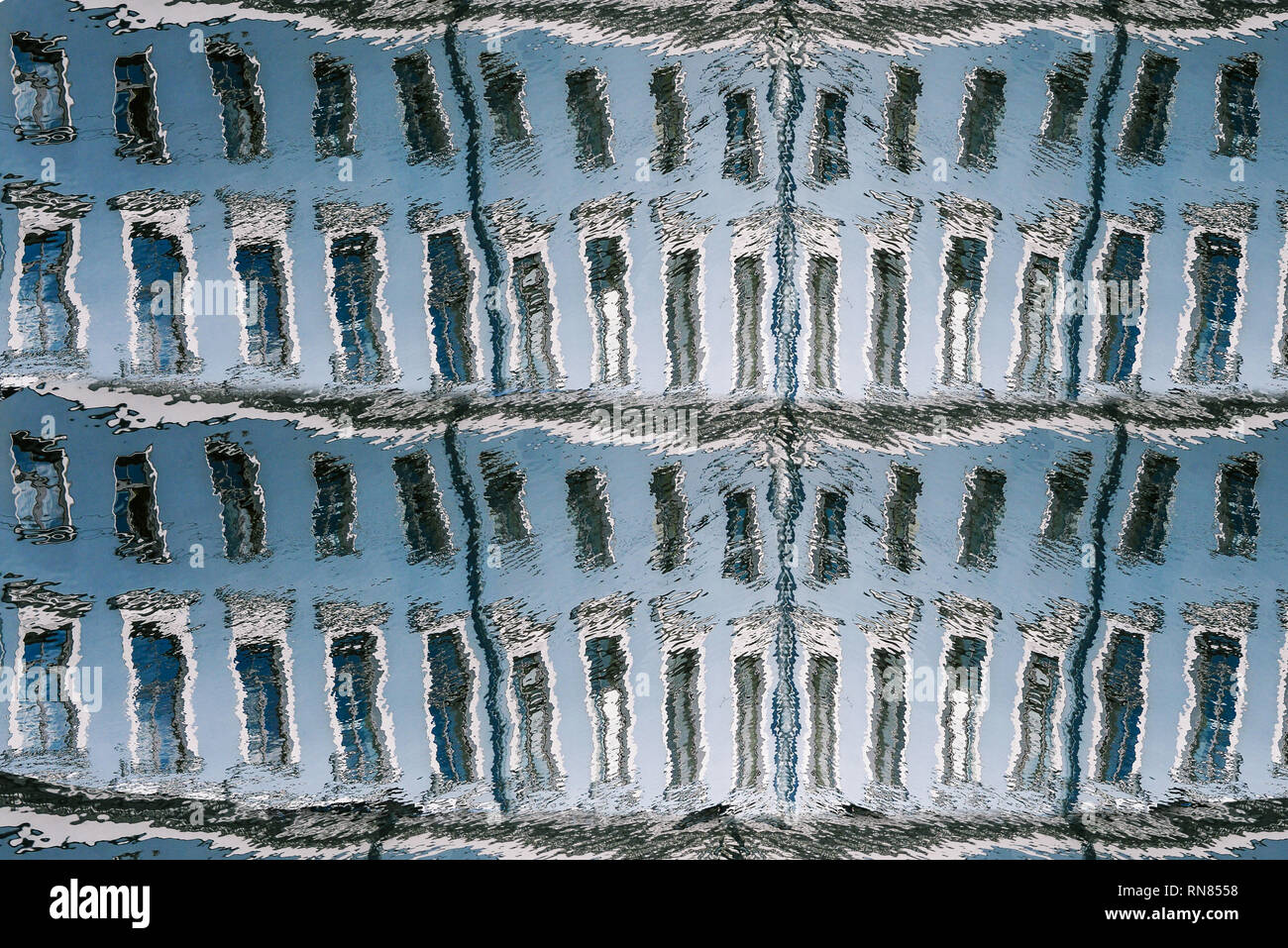 Reflection of a building in the water. Distorted walls and windows of ...