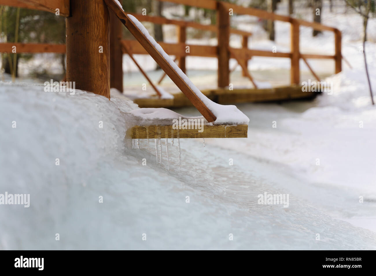 Icy wooden bridge, water runs over the ice, Krasnoyarsk, Russia ...