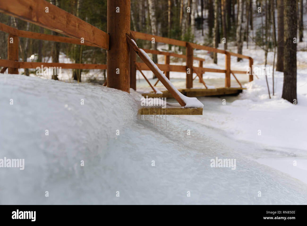 Icy wooden bridge, water runs over the ice, Krasnoyarsk, Russia ...