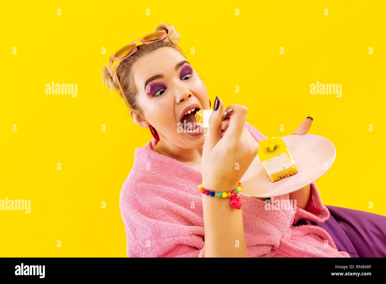 Woman feeling crazy while eating delicious sweet cake Stock Photo - Alamy