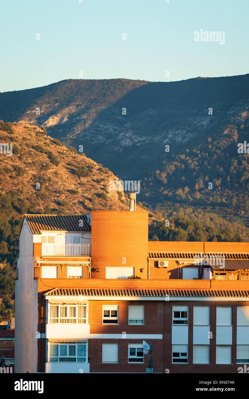 Apartament blocks in Spain during sunset with mountains in background ...