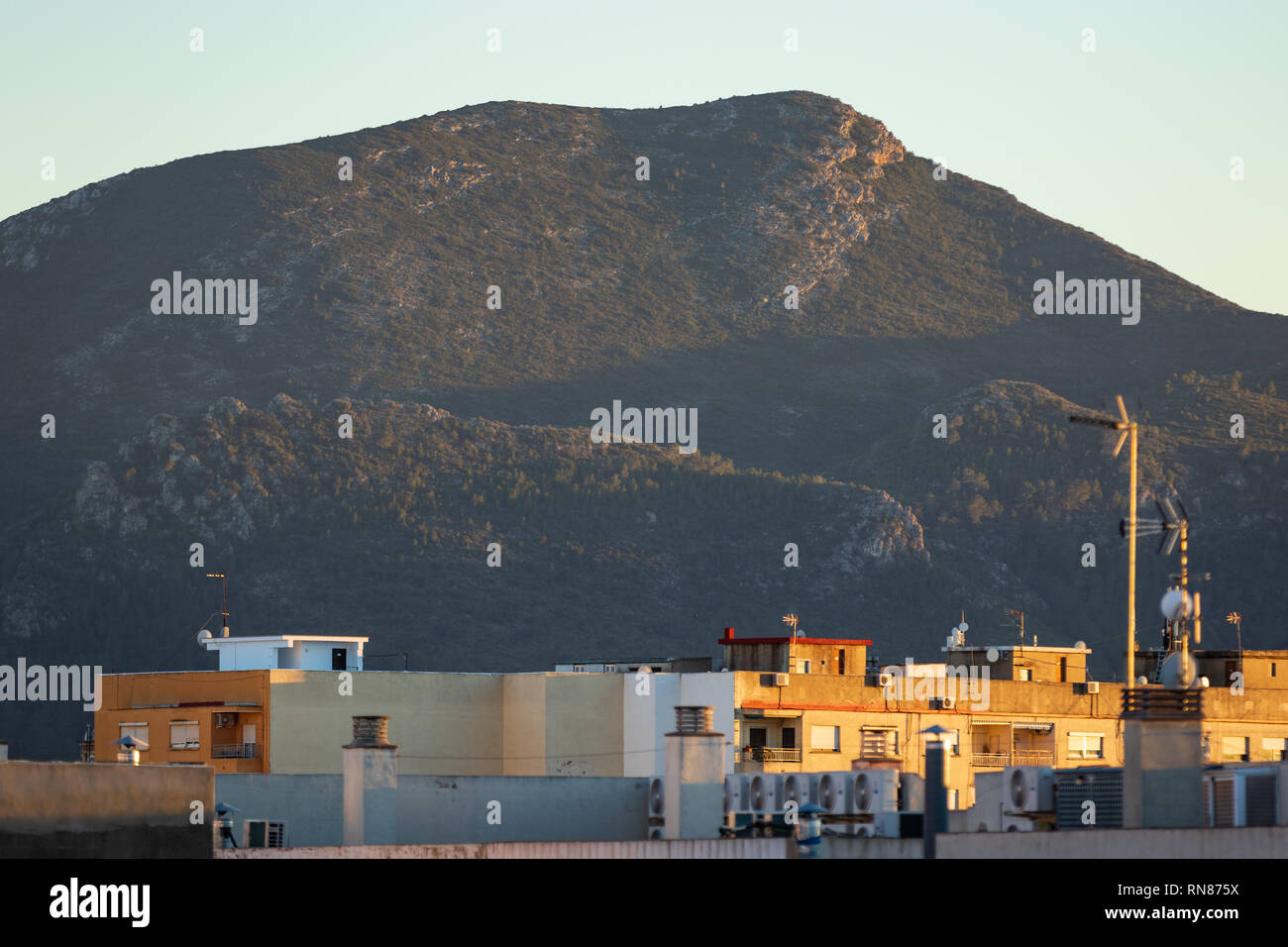 Apartament blocks in Spain during sunset with mountains in background ...