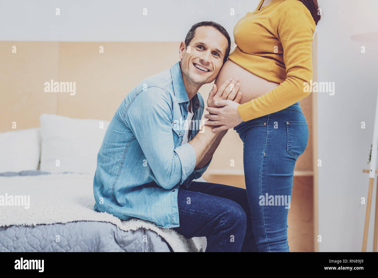 My baby. Handsome man expressing positivity while touching his wife ...