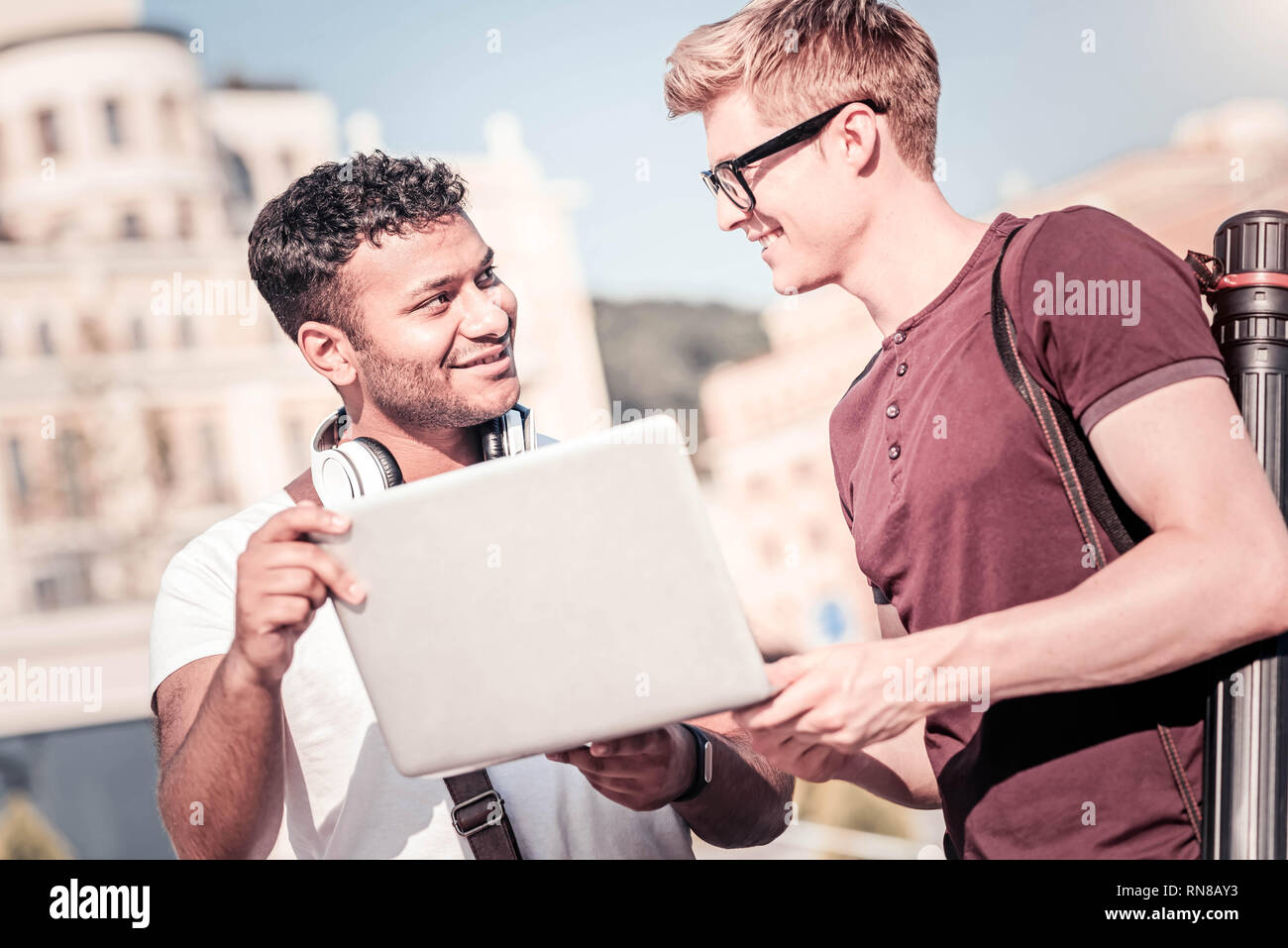 In all ears. Handsome foreigner keeping smile on his face and turning ...