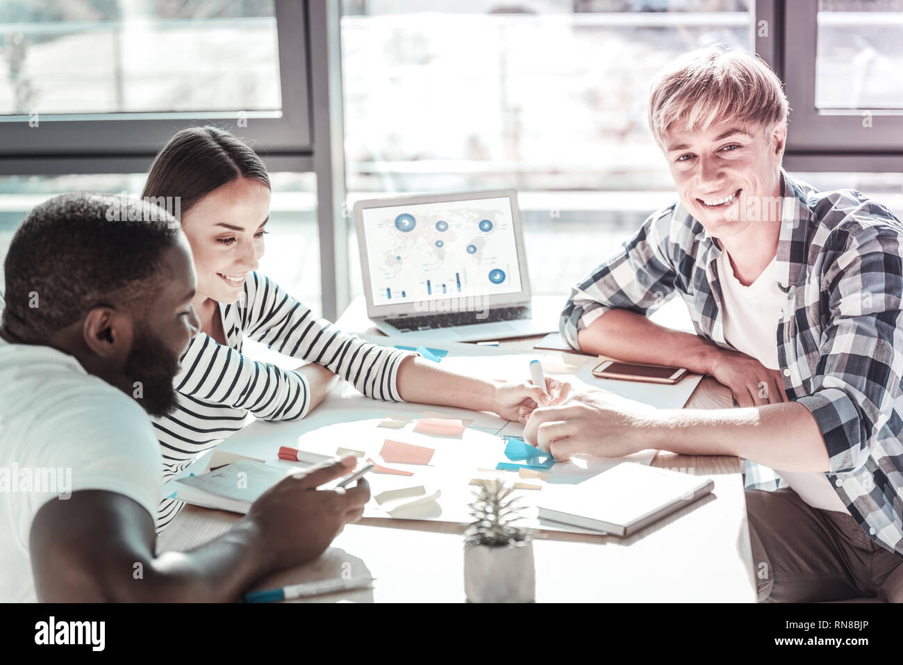 Helping them. Attentive colleagues leaning arms on table and bowing ...