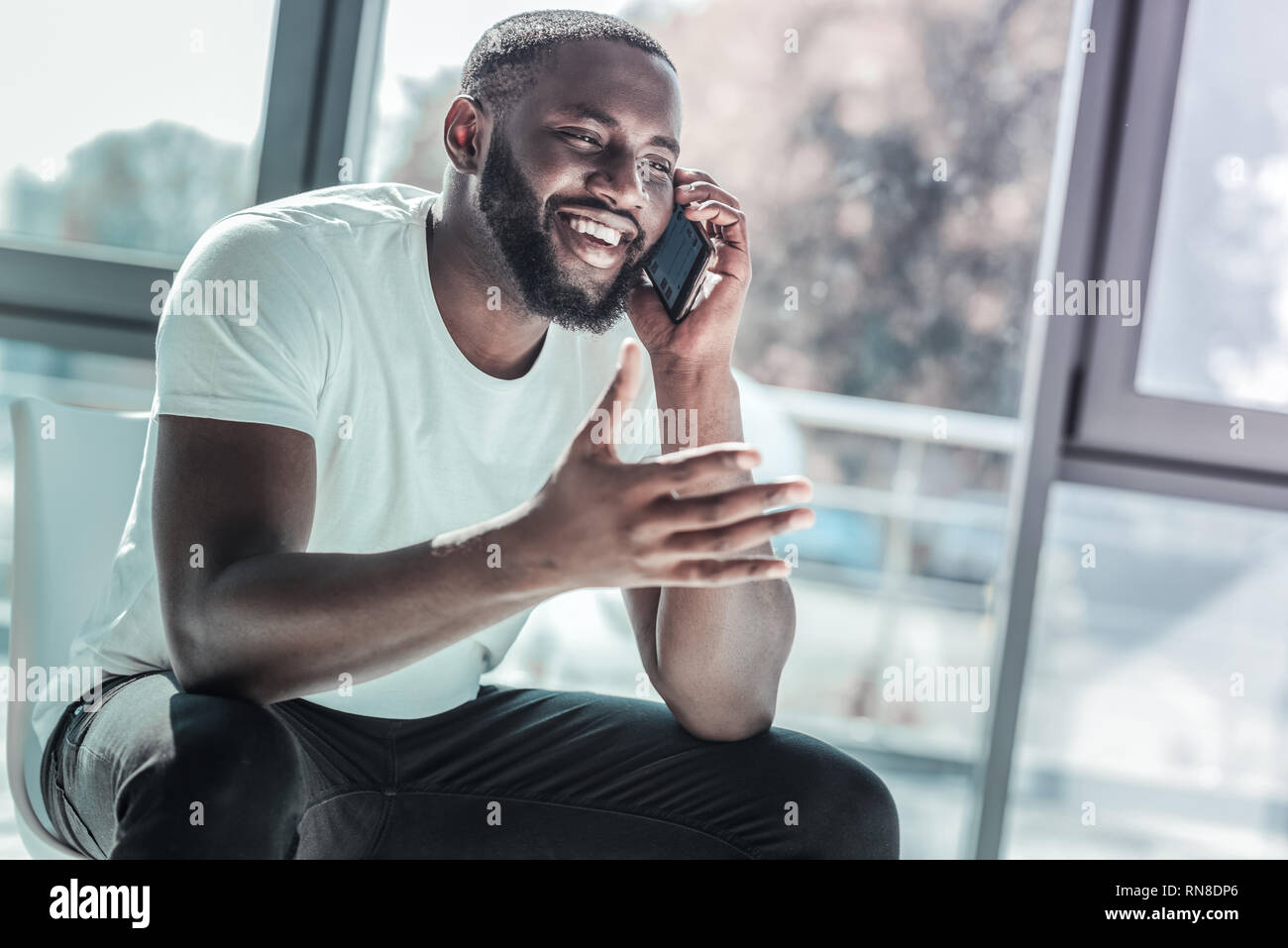 Telephone talk. Cheerful brunette smiling while actively gesticulating ...