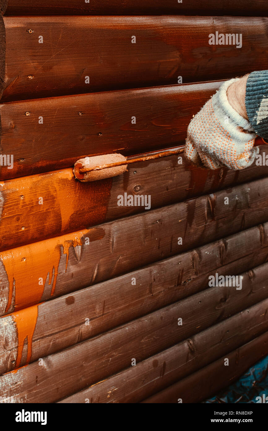 Hand of worker painting on wood wall new house at construction site ...