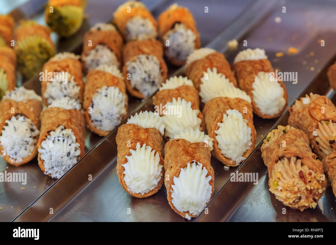 Freshly made traditional Italian cannoli with a variety of fillings on ...