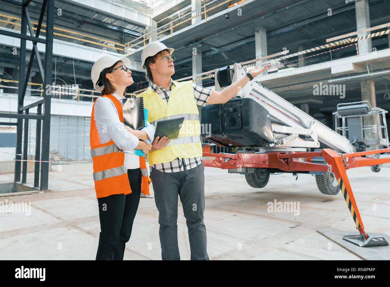 Woman engineer and man builder at construction site. Building ...