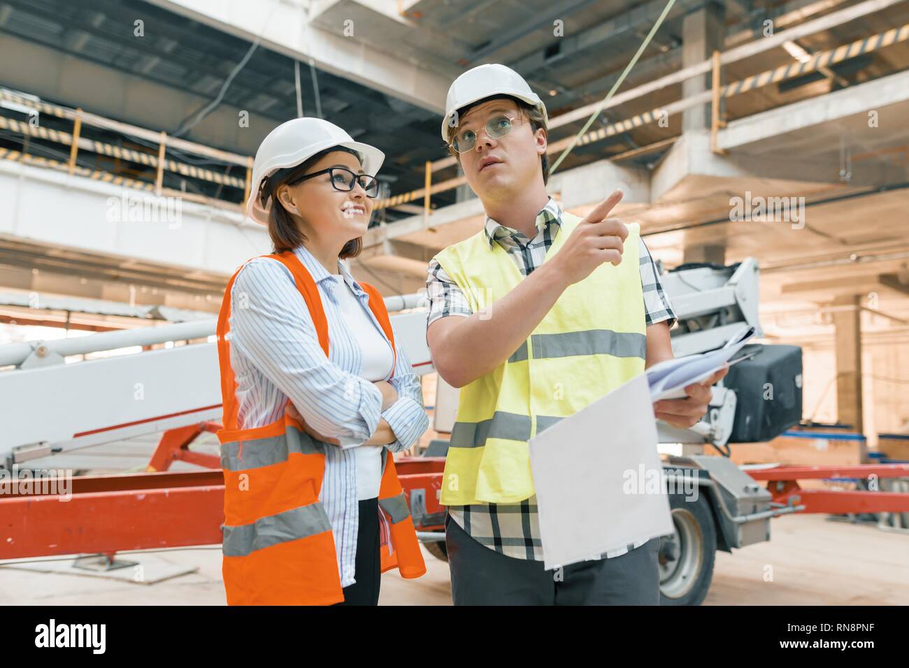 Woman engineer and man builder at construction site. Building ...