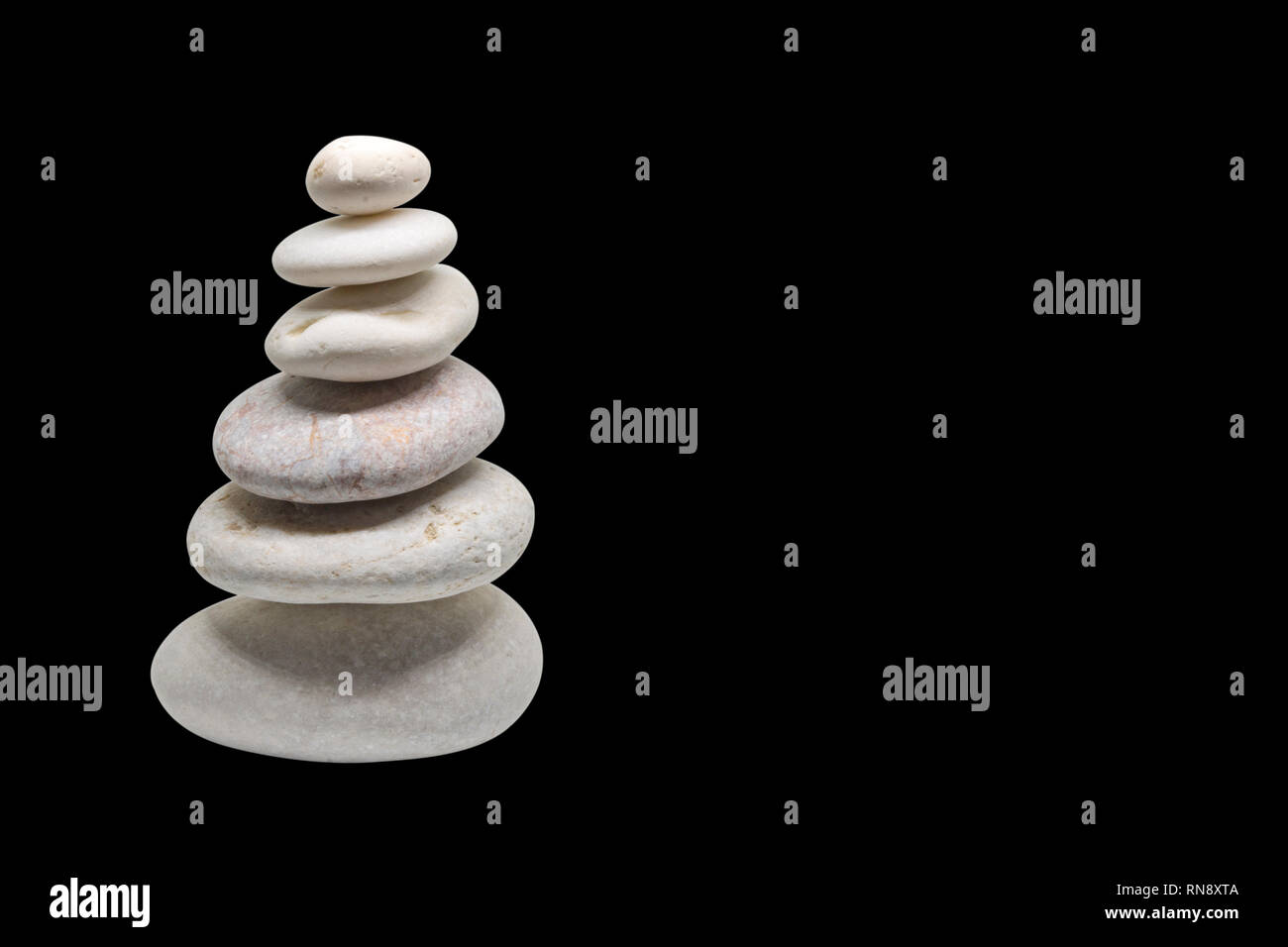 stacked pebbles isolated with black background Stock Photo - Alamy
