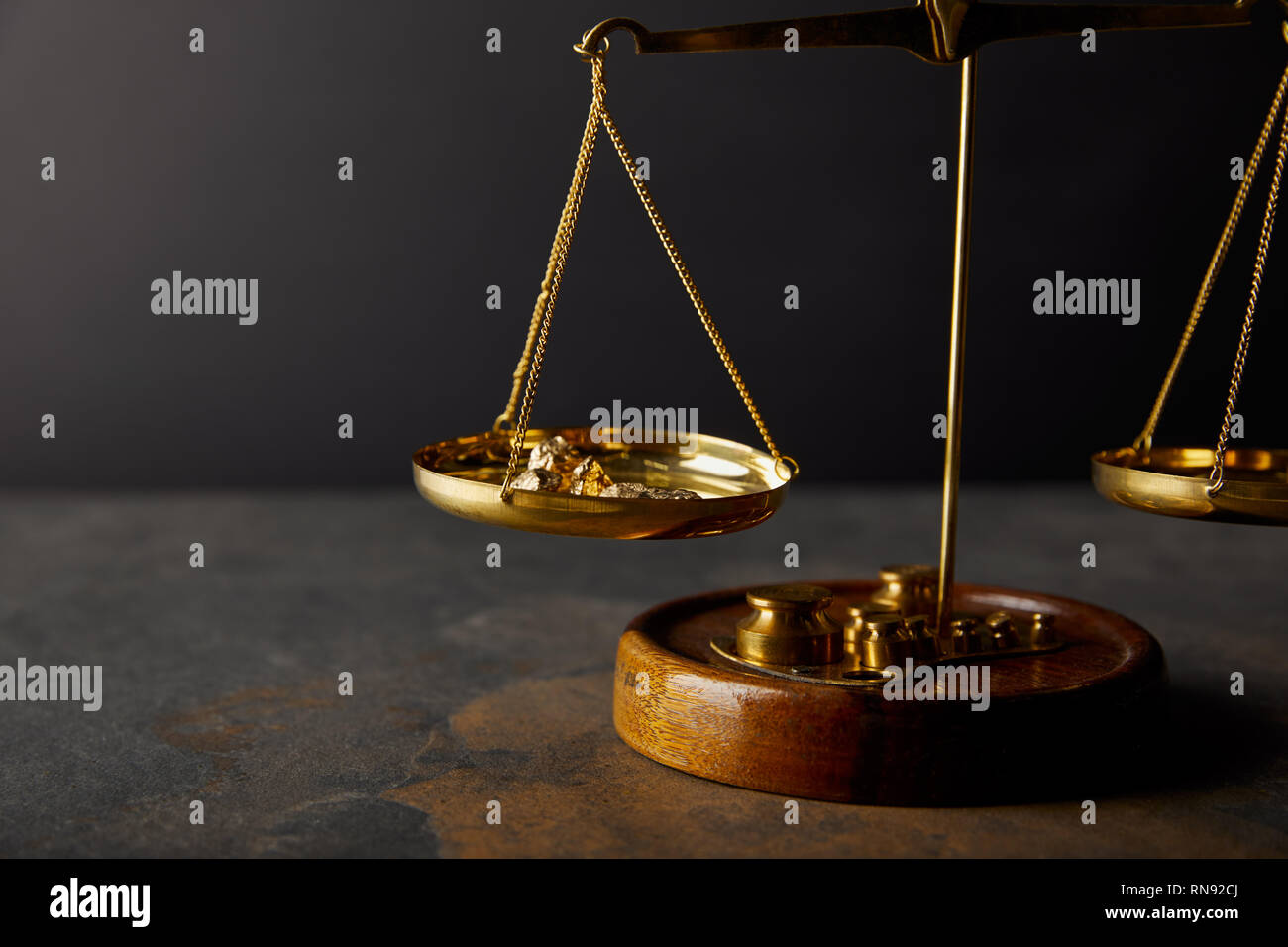 golden stones on scales on marble surface and black background Stock ...