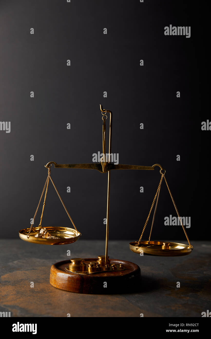 vintage scales with golden stones on marble surface and black ...