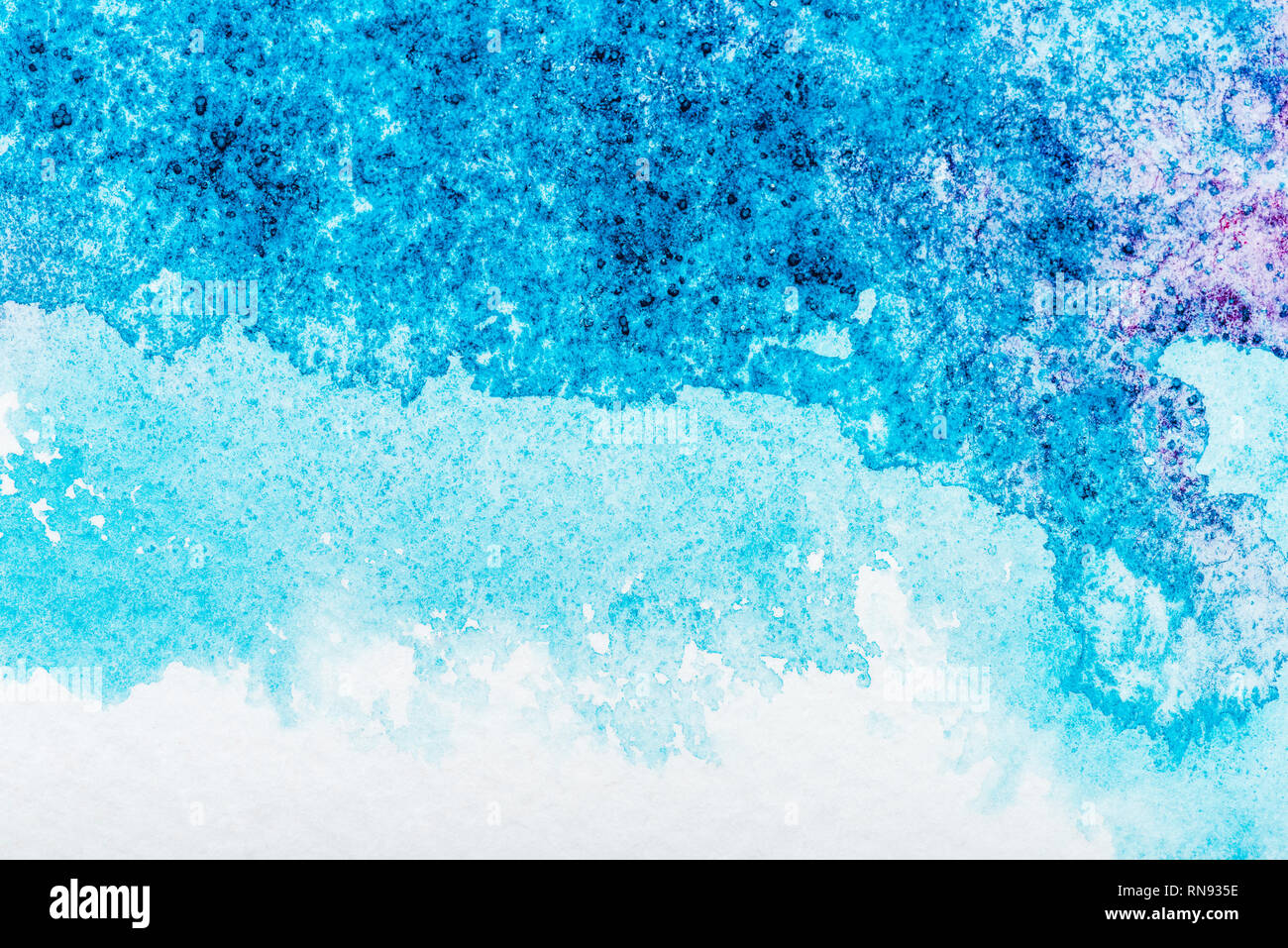 top view of blue watercolor spill on white background with copy space ...