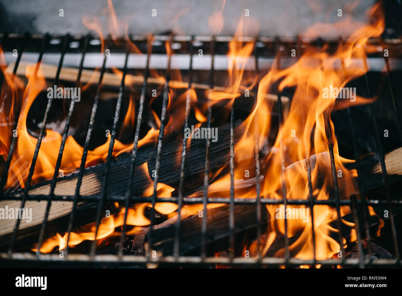 burning firewood with flame through bbq grill grates Stock Photo - Alamy